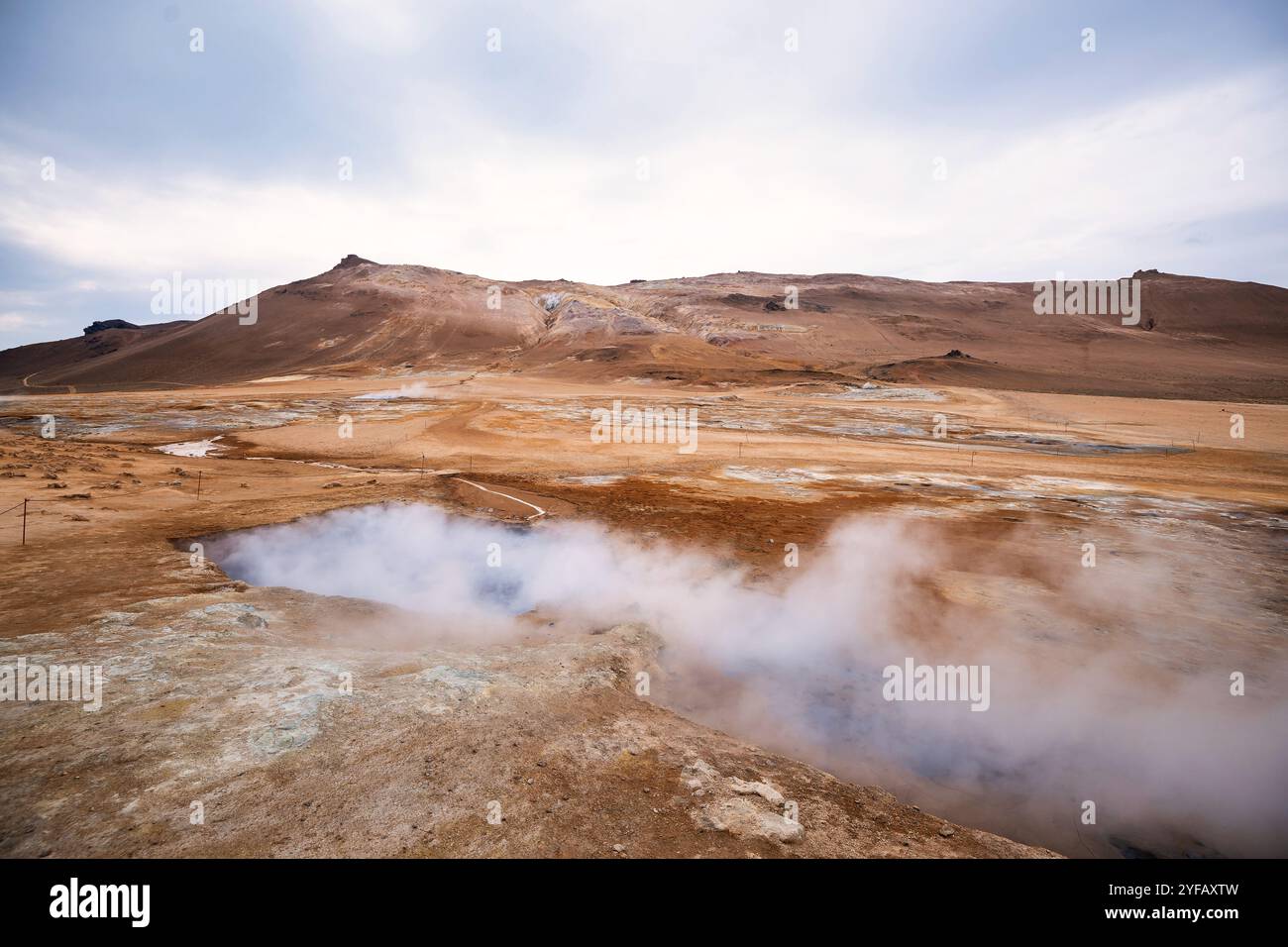 Boiling mudpots in the geothermal area Hverir and cracked ground around ...