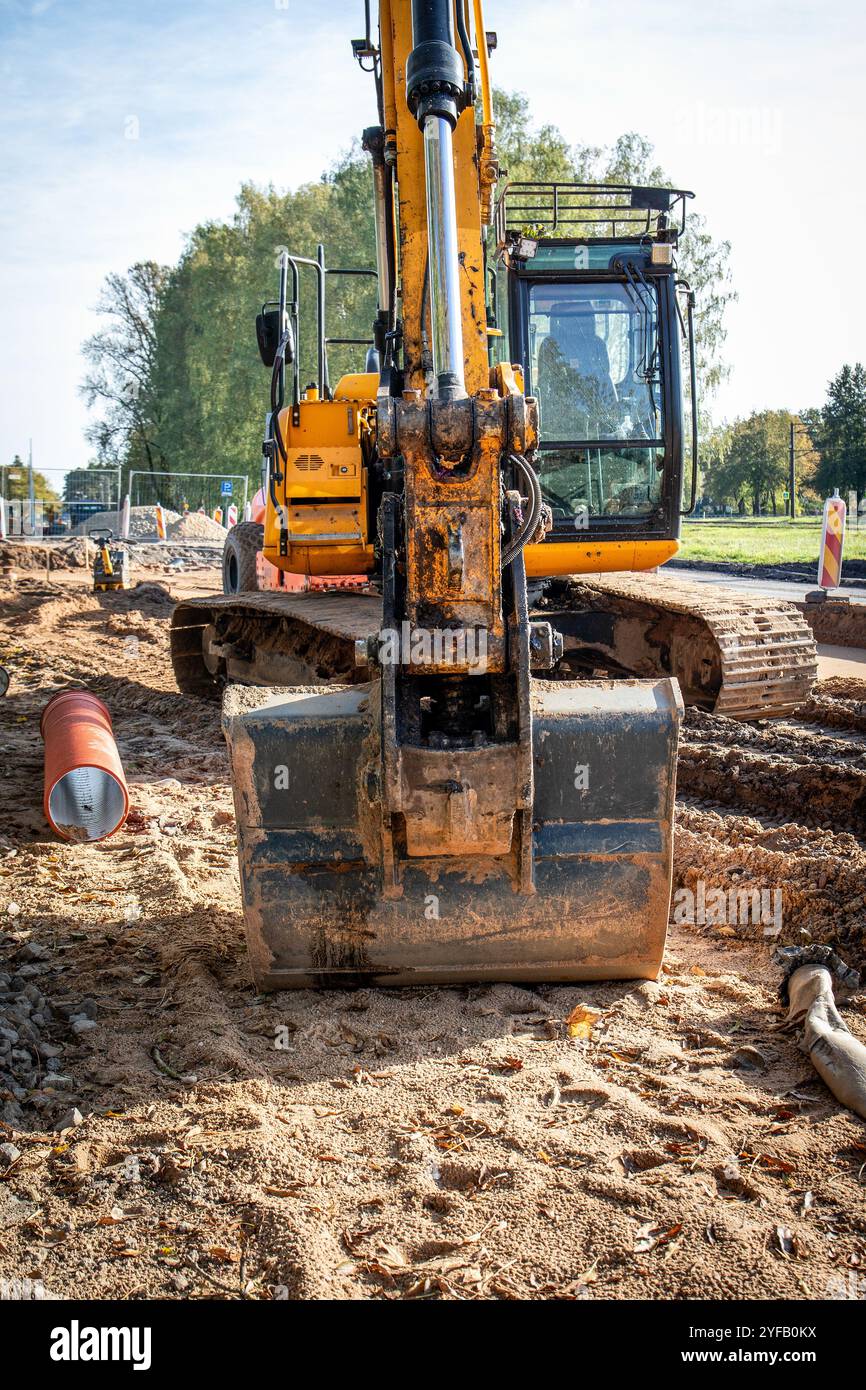 Huge yellow excavator with tracks and a bucket. Construction site and ...