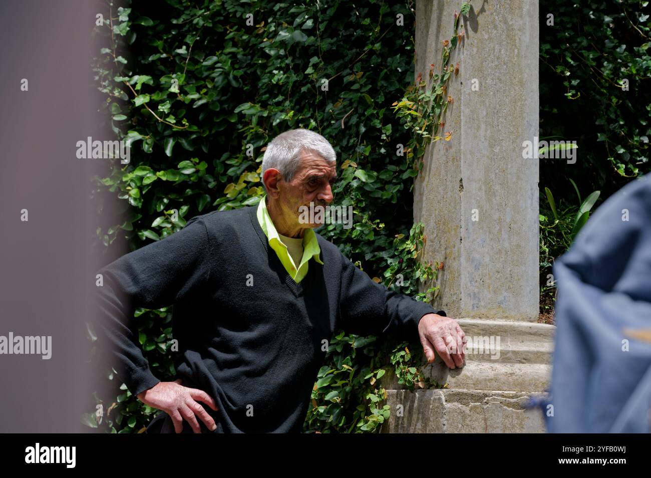 Portrait of an elder local man in Madeira, resting against a stone ...
