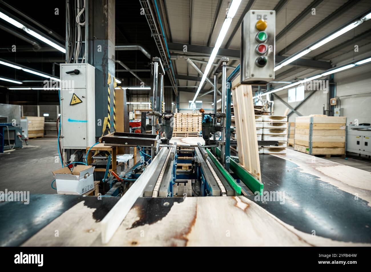 A large woodworking factory with stacks of freshly cut timber panels ...