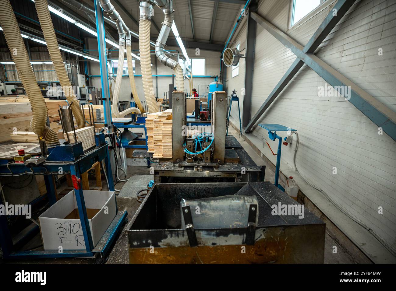 Industrial woodworking facility with stacks of wooden planks and ...