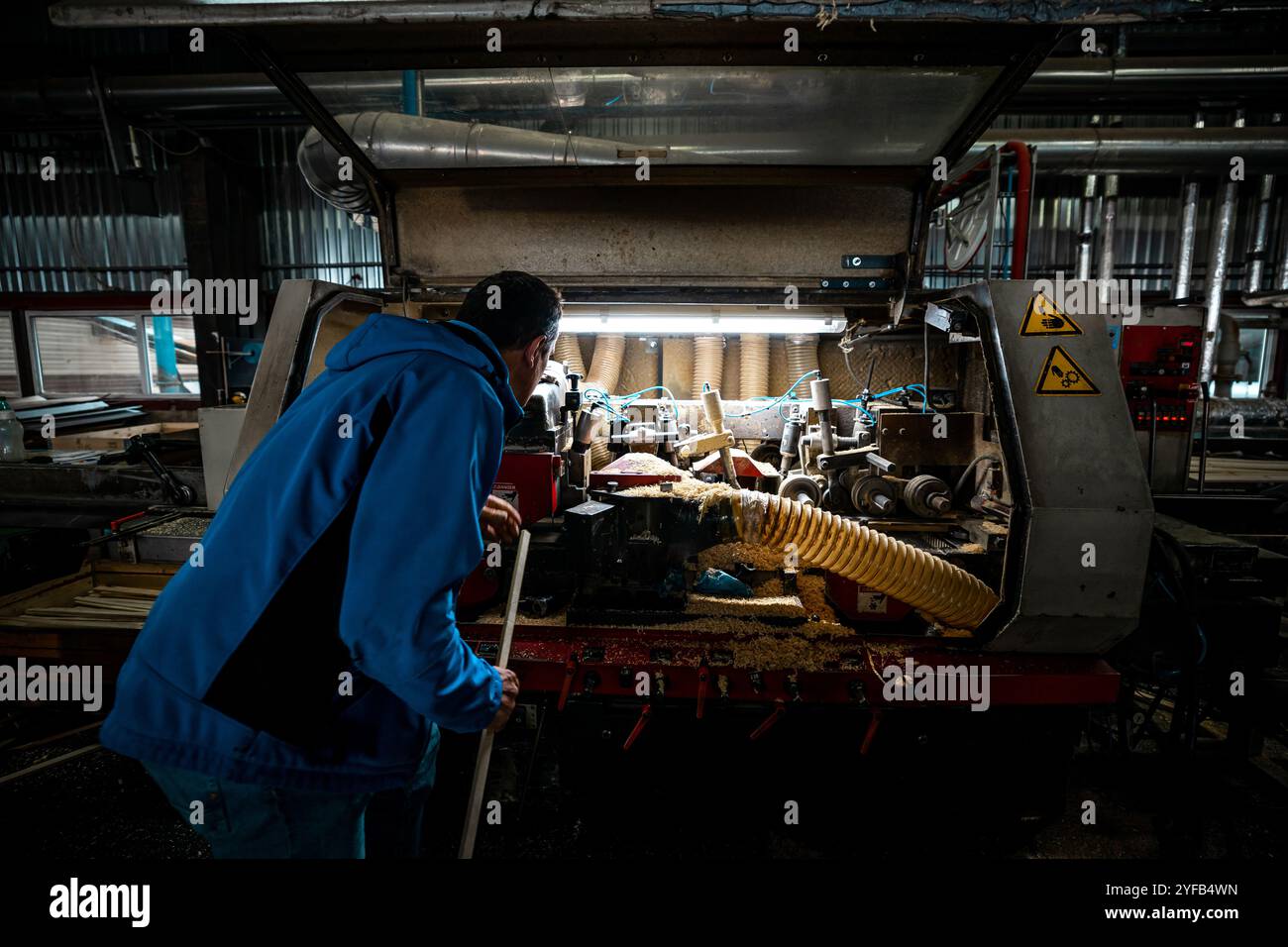 Worker operating machinery in a factory, focusing on precision and ...
