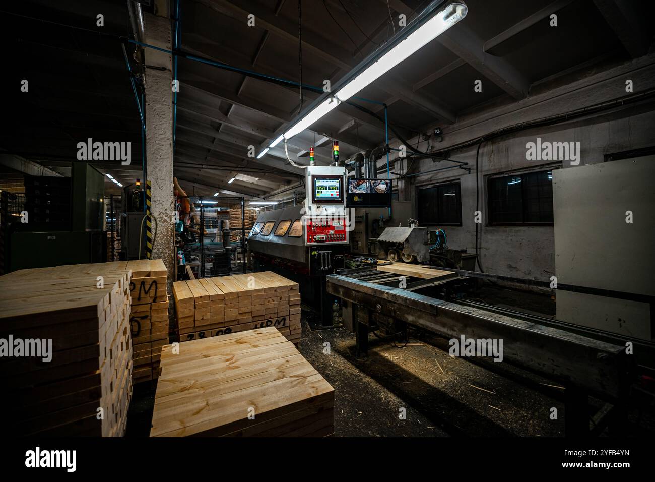 A large woodworking factory with stacks of freshly cut timber panels ...