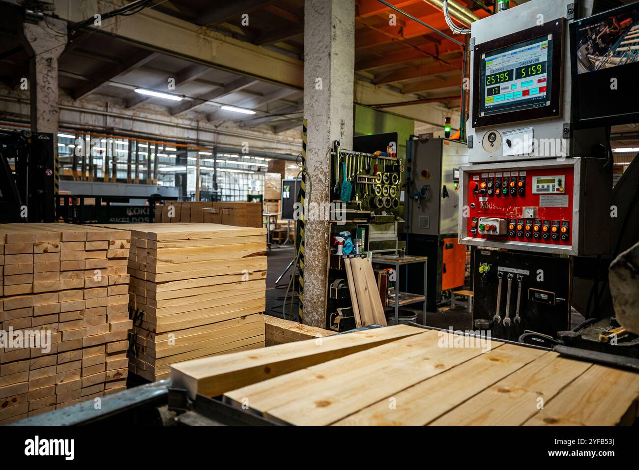 Industrial woodworking facility with stacks of wooden planks and ...