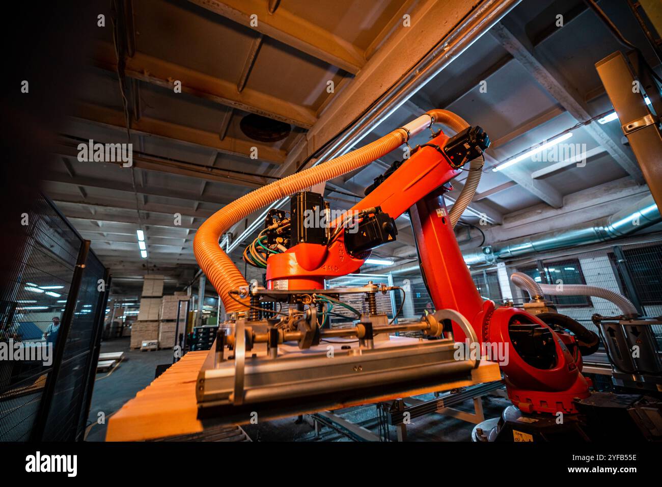 A robotic arm in a woodworking factory, equipped with suction ...
