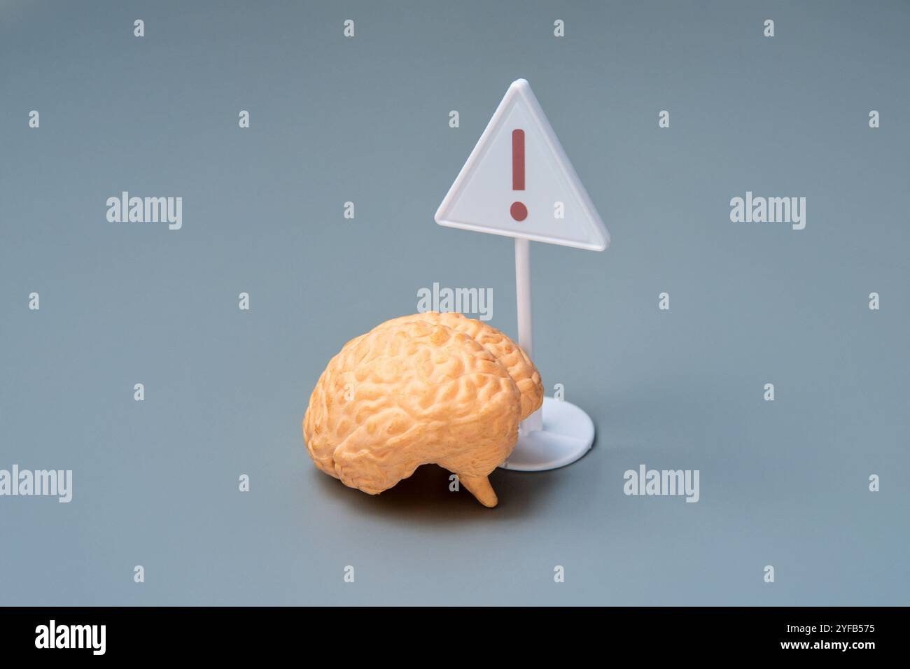 A brain model with a warning sign. Brain health and the potential risks ...