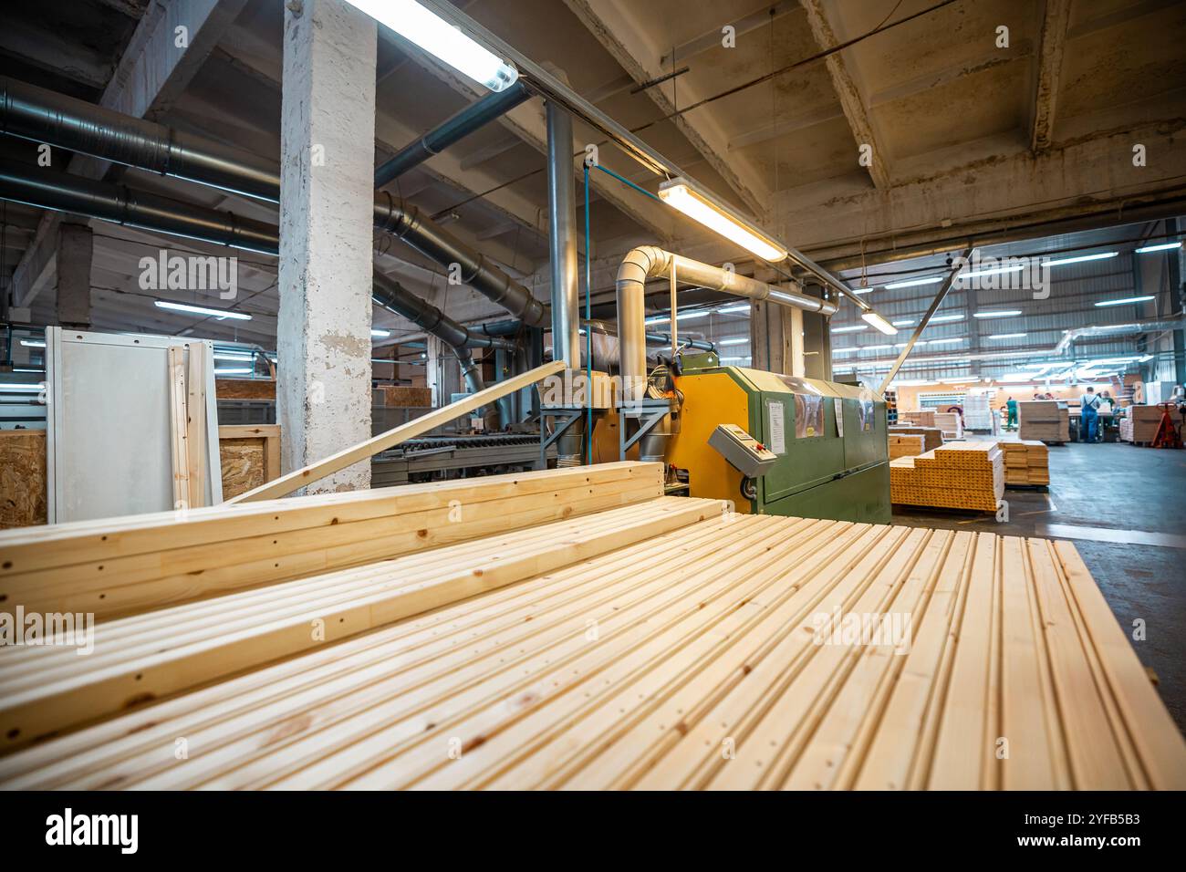 A large woodworking factory with stacks of freshly cut timber panels ...