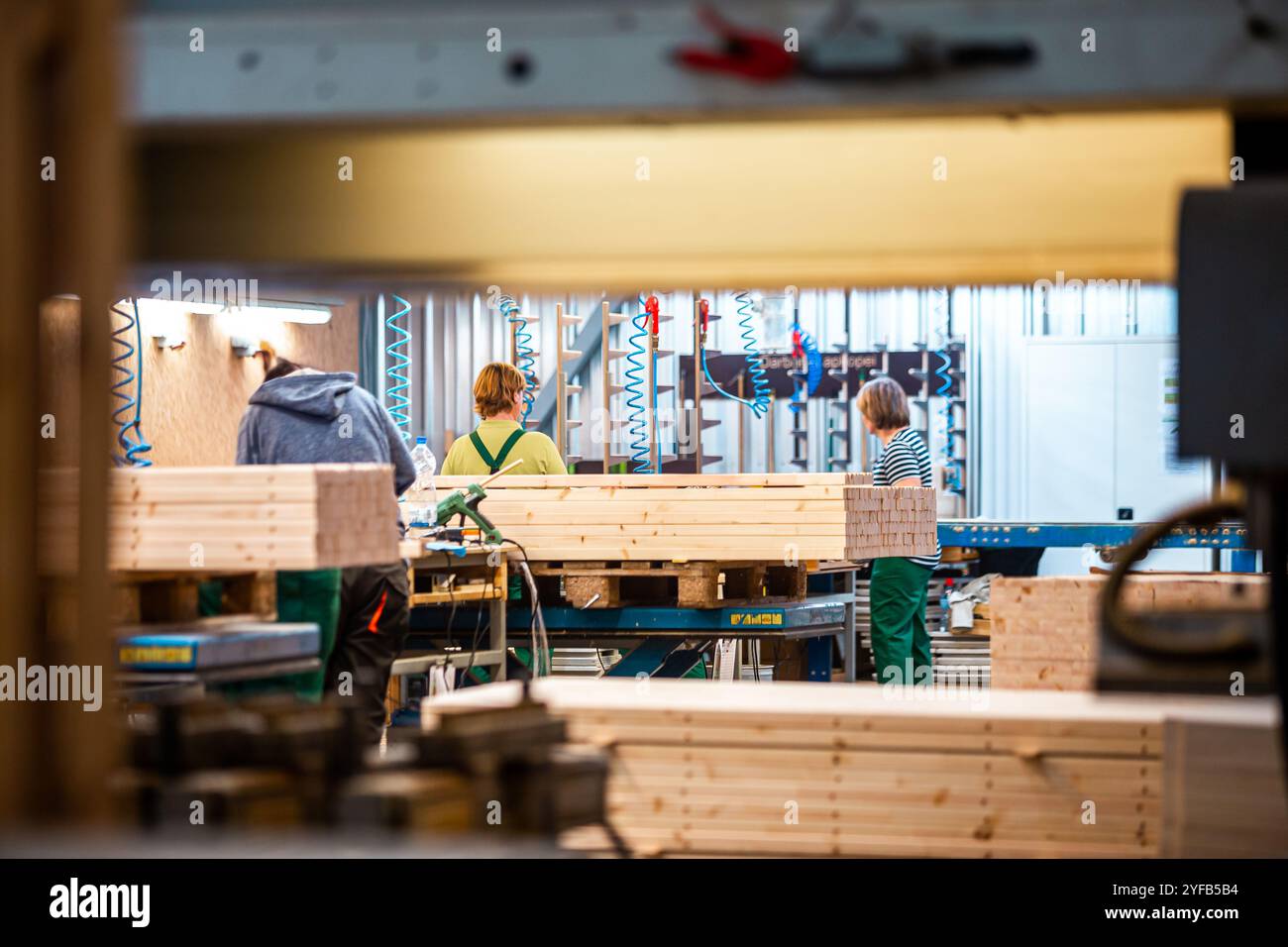 Industrial woodworking facility with stacks of wooden planks and ...