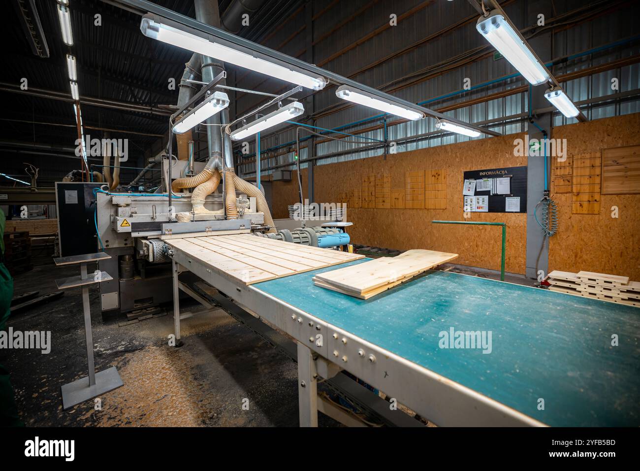 woodworking factory with an automated machine processing wooden boards ...