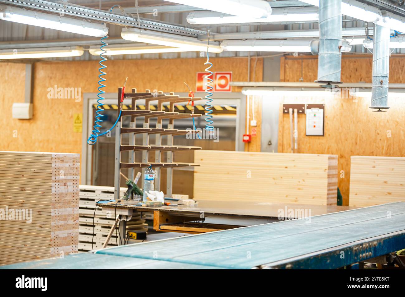 Industrial woodworking facility with stacks of wooden planks and ...
