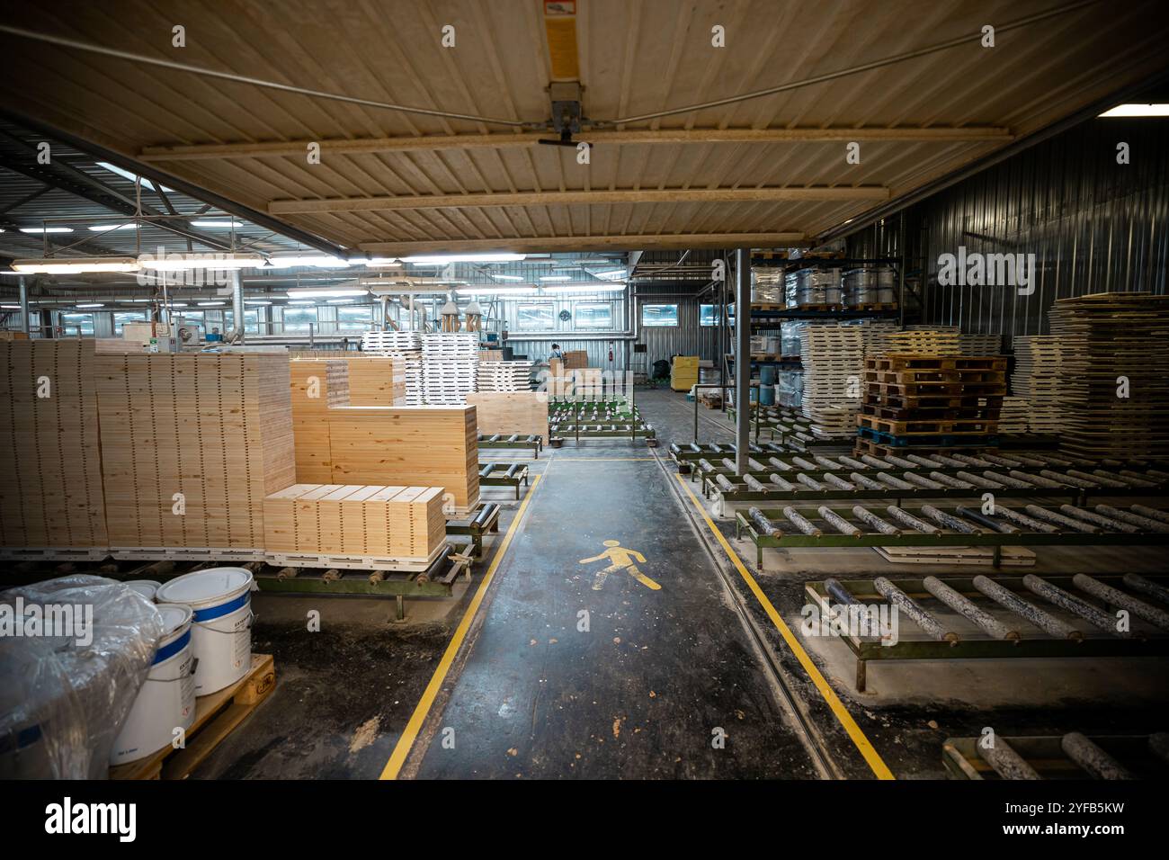 A large woodworking factory with stacks of freshly cut timber panels ...