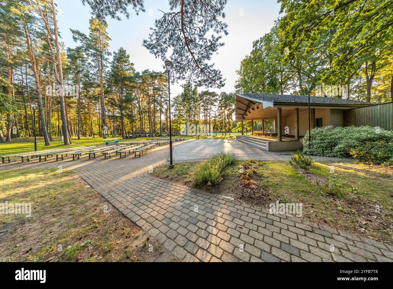 An outdoor amphitheater in a wooded park with long benches arranged in ...