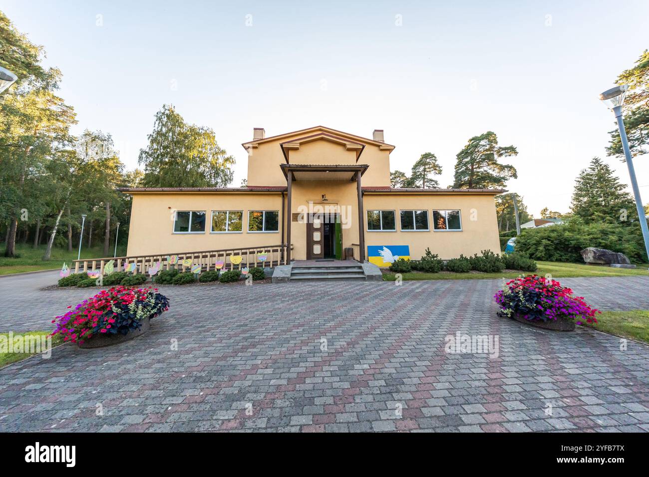 A bright yellow building with a pathway leading to its entrance ...