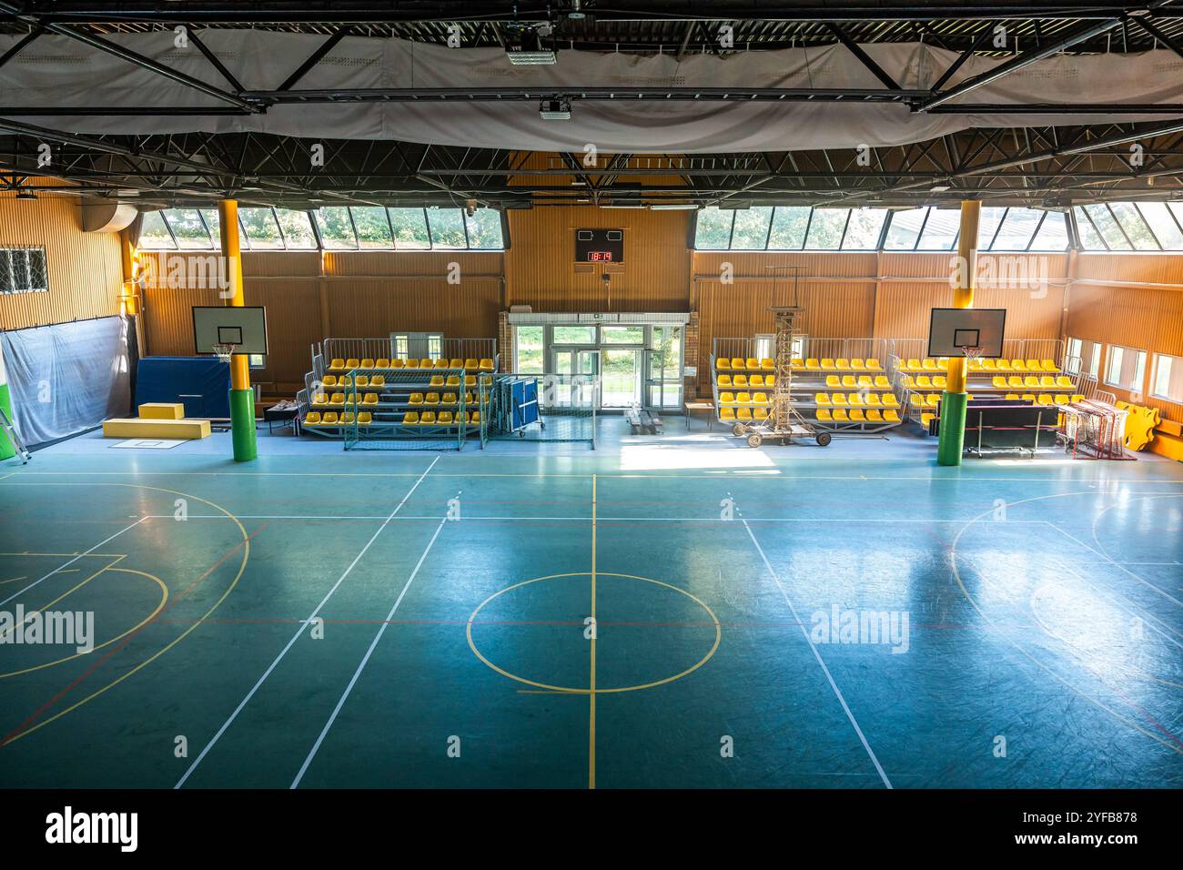 Basketball court inside a large indoor gym with seating, high ceilings ...