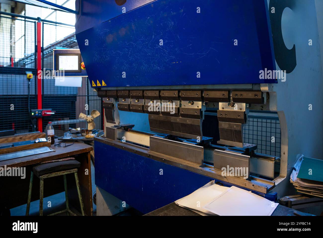 Worker prepares a metal sheet on an industrial press machine, focusing ...