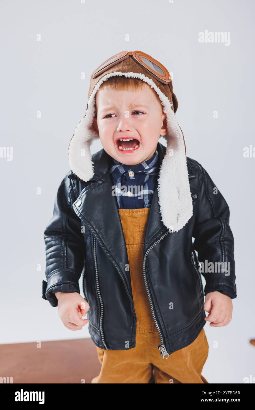 A little boy of 3 years old is crying and screaming with emotion. An ...