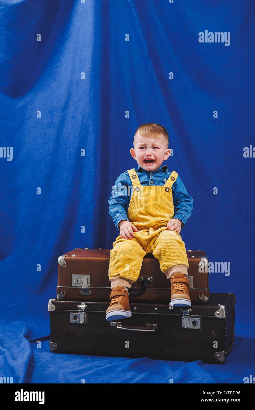 A little boy of 3 years old is crying and screaming with emotion. An ...