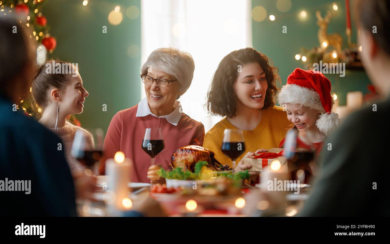 Merry Christmas. Happy family are having dinner at home. Celebration holiday and togetherness ...