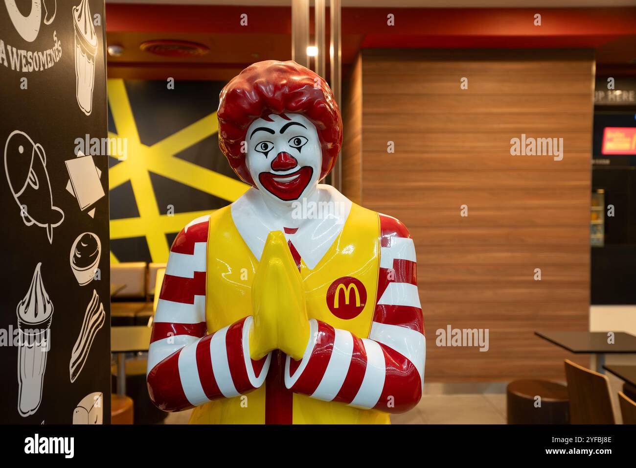 BANGKOK, THAILAND - OCTOBER 14, 2023: life-size Ronald McDonald statue greeting customers with ...
