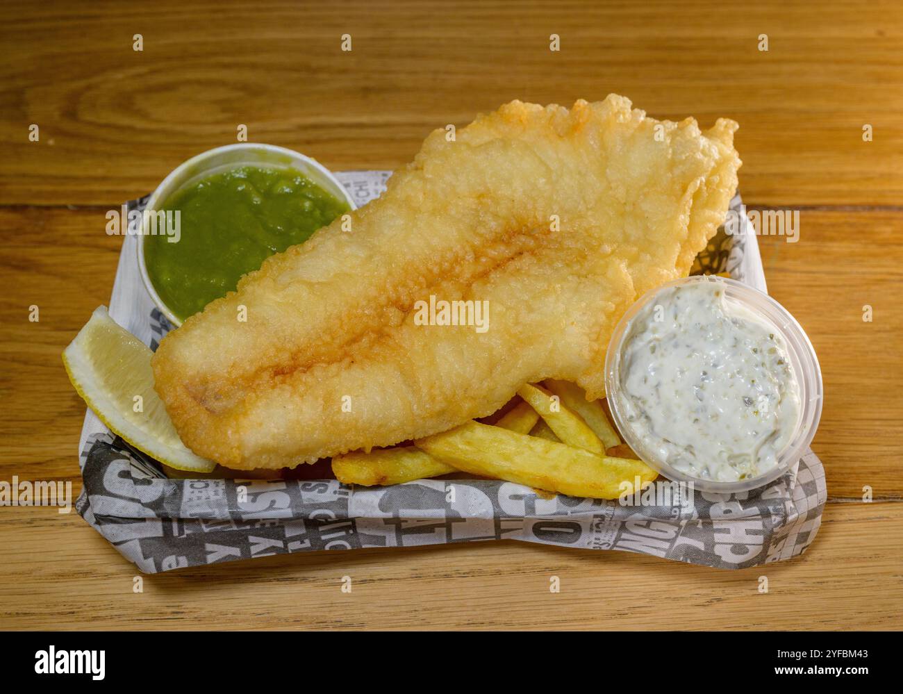 Traditional fish and chips wrapped in newspaper form a chip shop Stock ...
