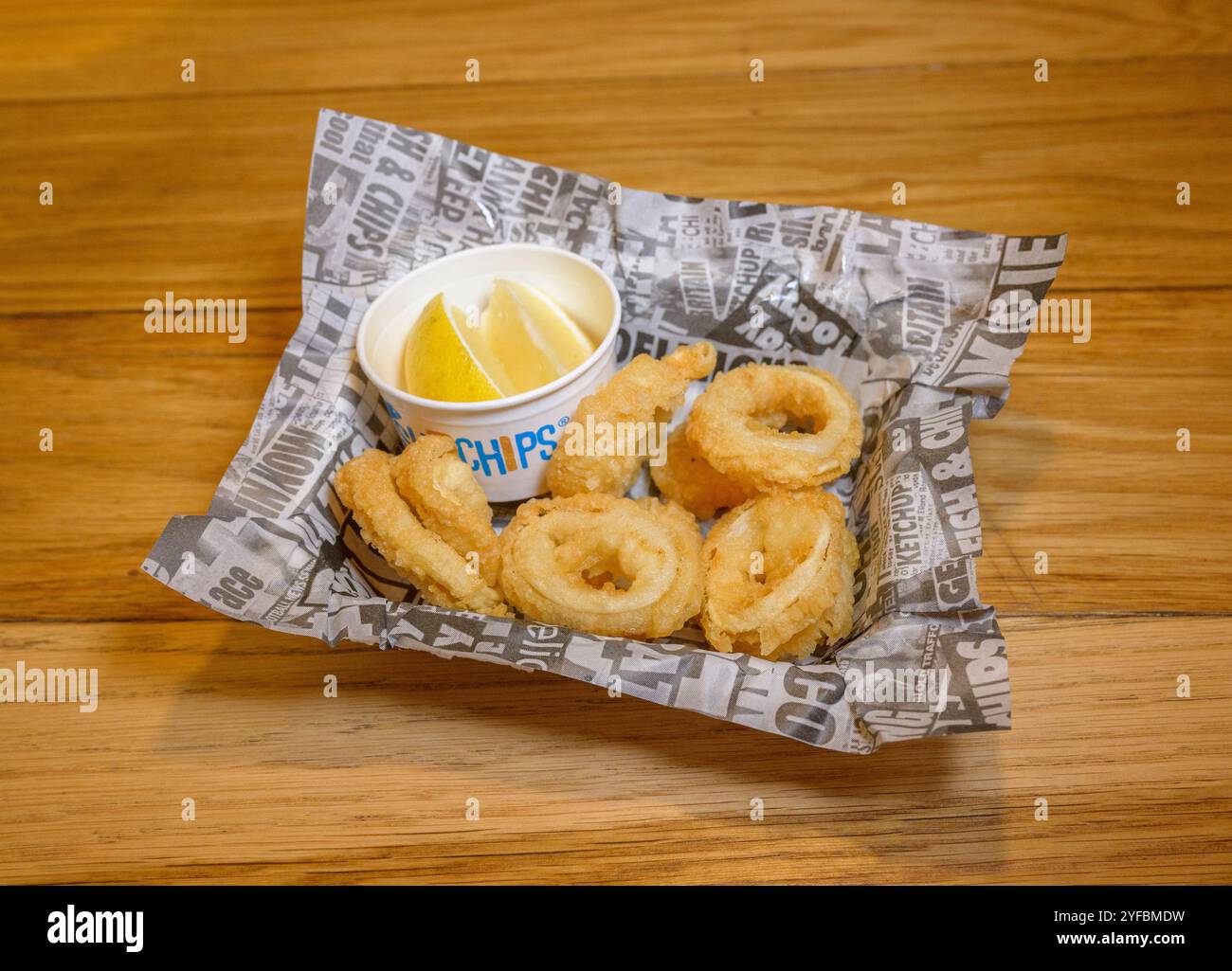 Calamari and chips wrapped in newspaper form a chip shop Stock Photo ...