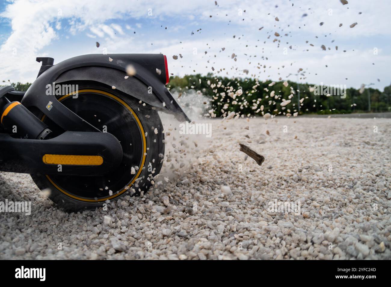 Starting a scooter on a gravel road with slipping and flying stones ...