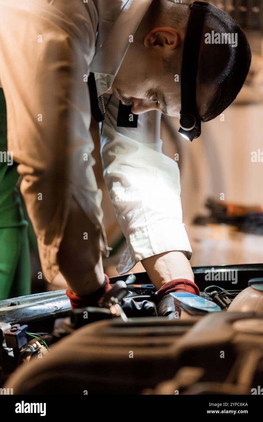 Mechanic Diagnosing Engine Troubles with Precision Under Work Light ...
