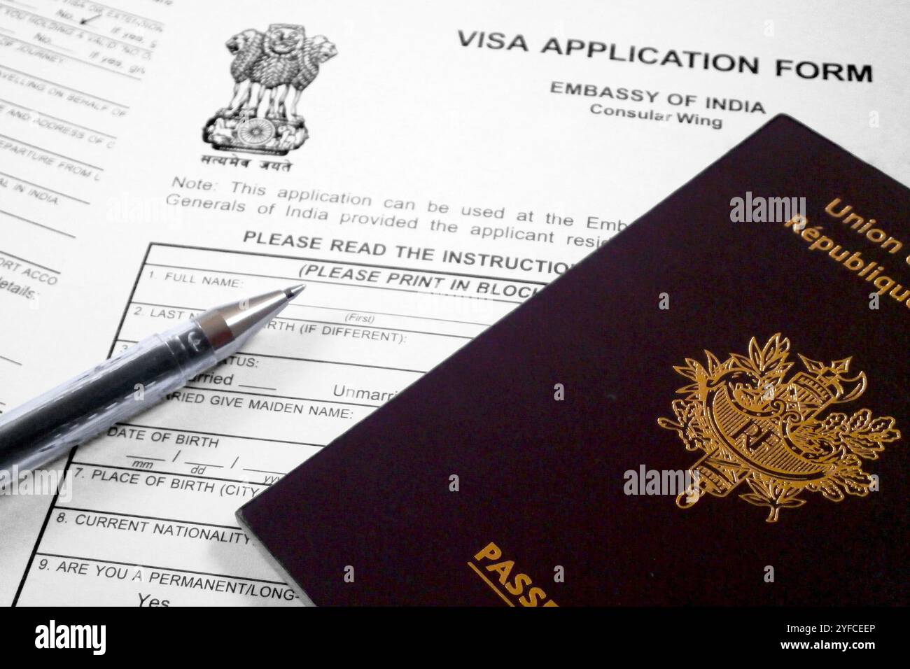 A pen and a French passport on the top of a visa application form for ...