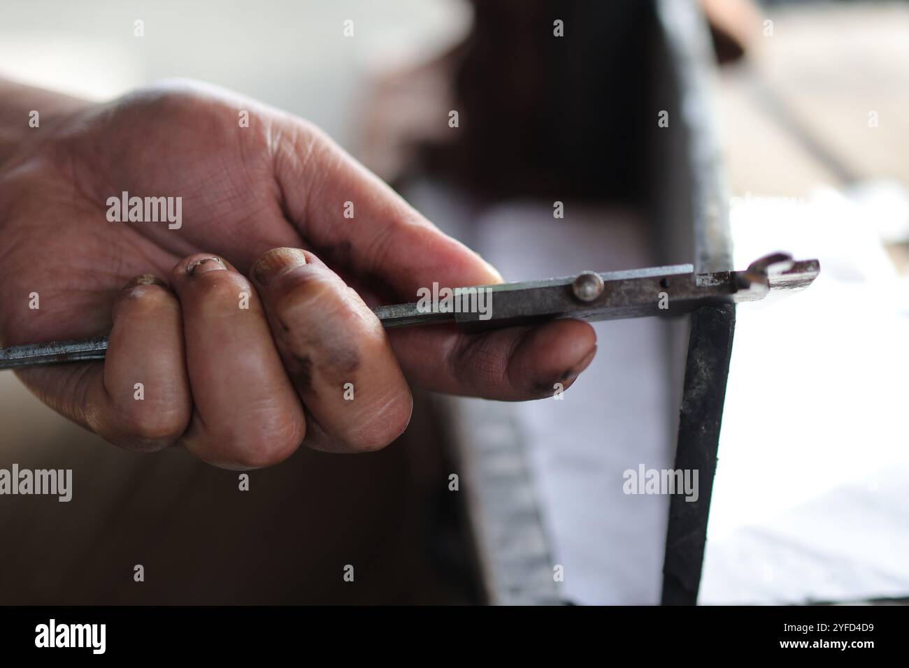 Close-up of a skilled artisan hands using a metal tool to handcraft an ...