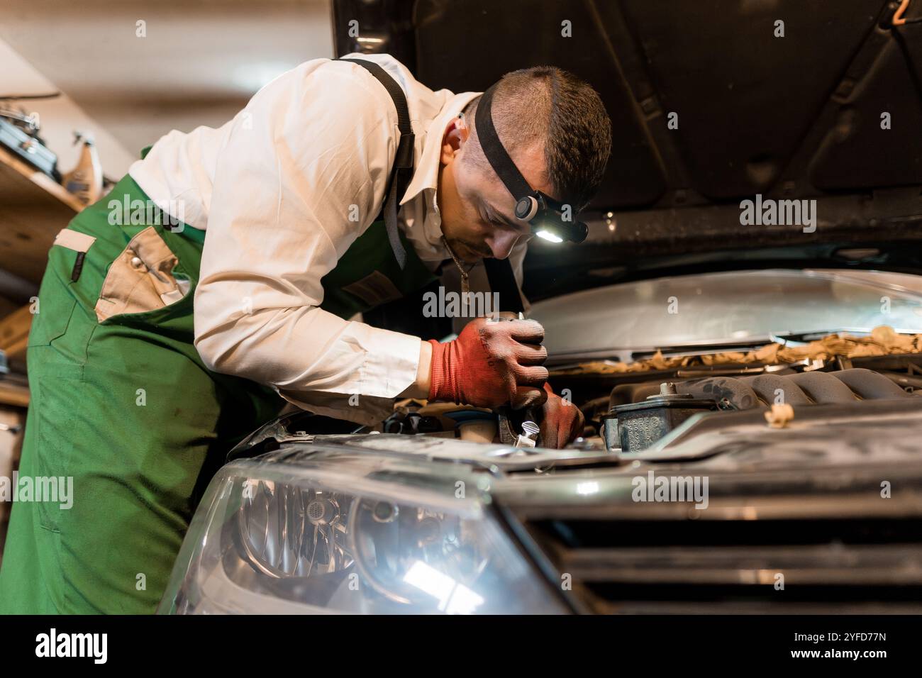 Mechanic Repairing an Engine Under Dim Light Stock Photo - Alamy