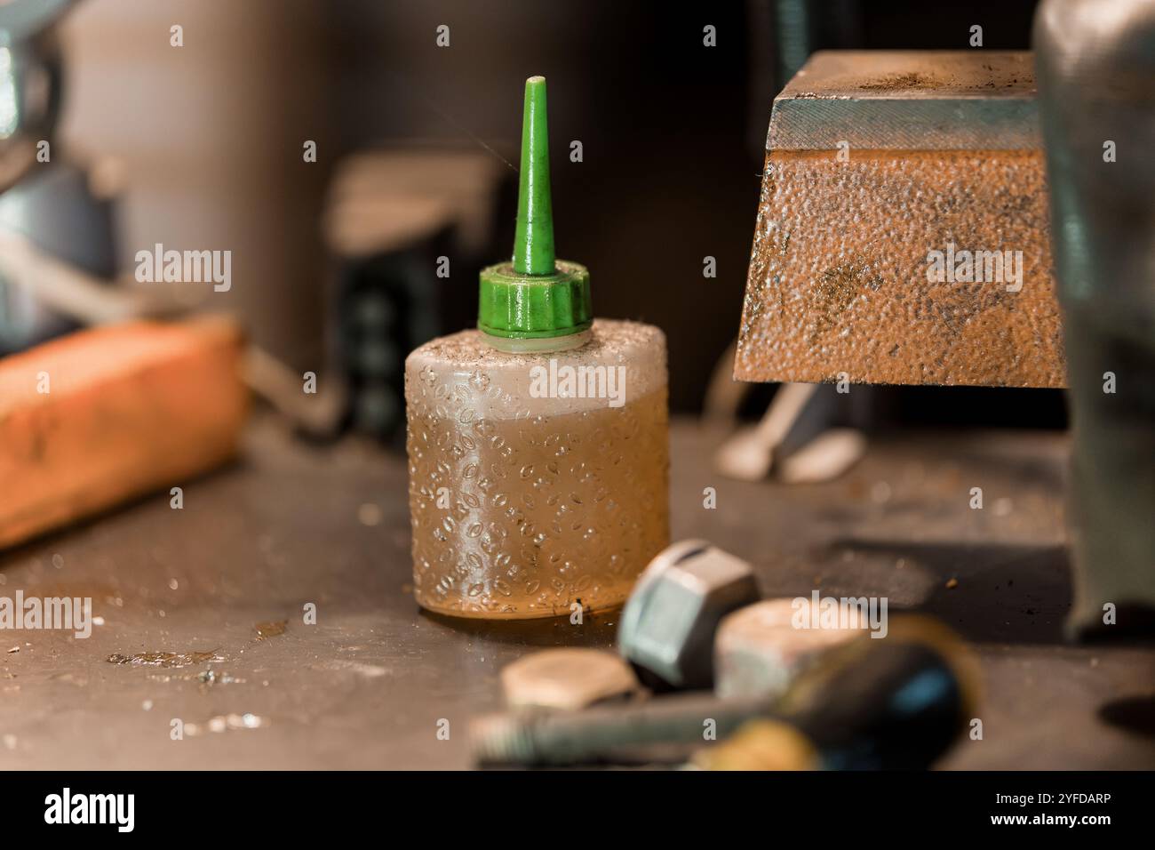 Bottle of Lubricating Oil on a Workbench Surrounded by Tools and Metal ...