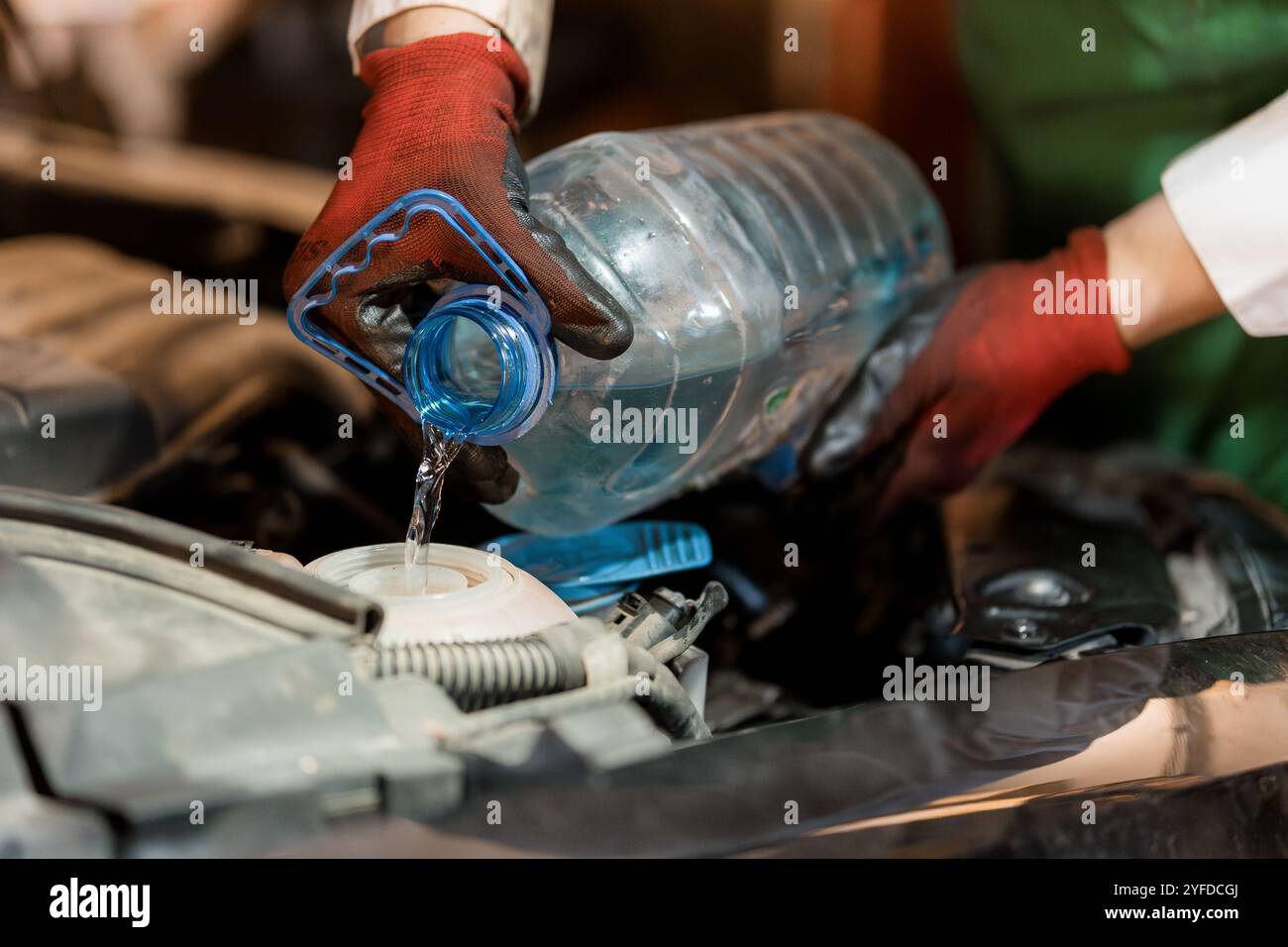 Car Maintenance: Filling Coolant from a Plastic Bottle into an Engine ...