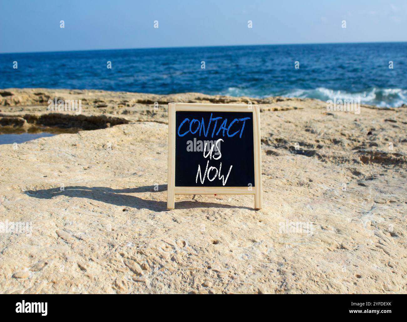 Contact us now symbol. Blackboard with words Contact us now. Beautiful ...