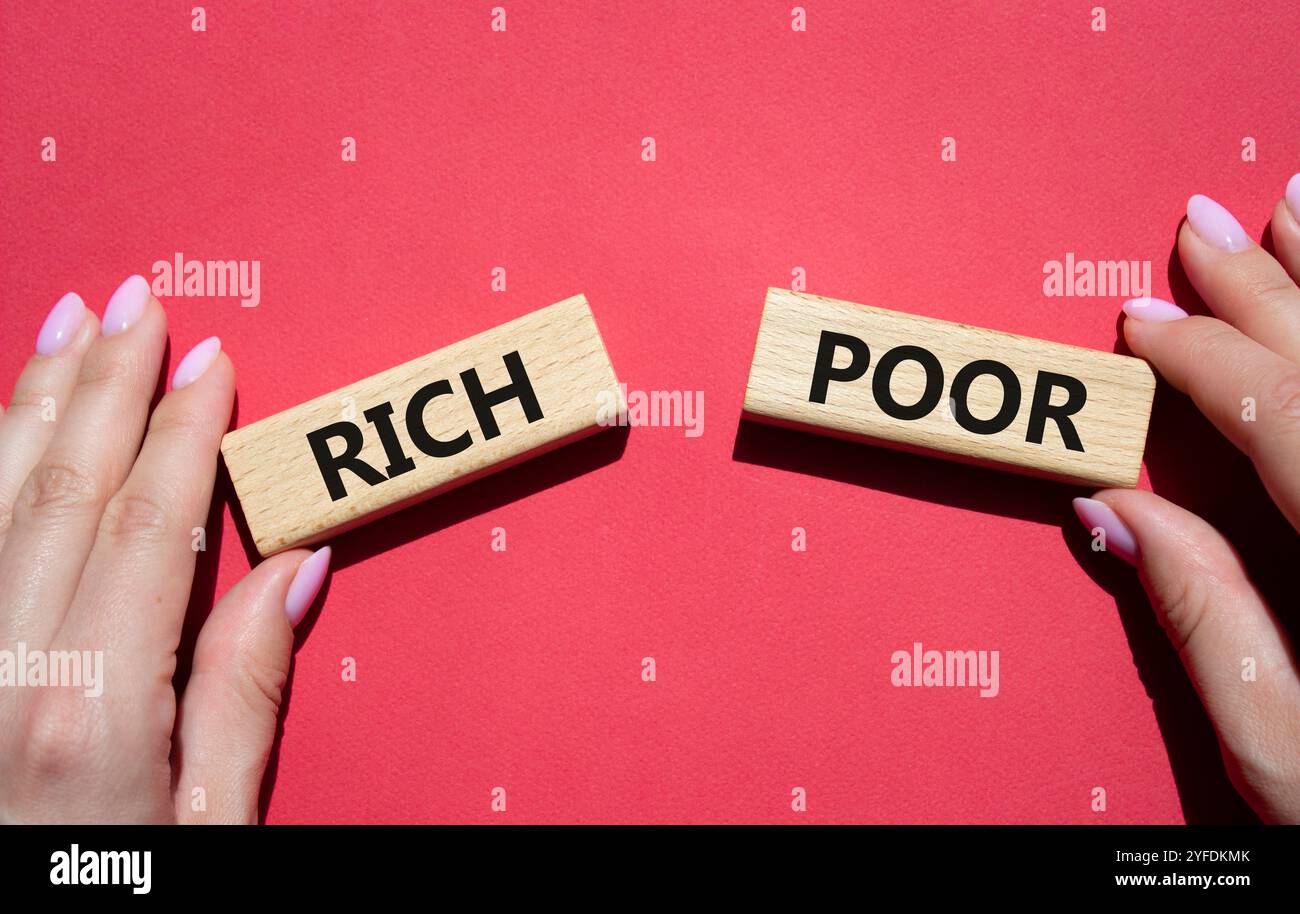 Rich vs Poor symbol. Concept word Rich vs Poor on wooden blocks. Businessman hand. Beautiful red ...