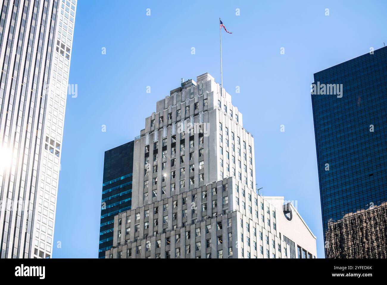 A skyscraper in New York City with an American flag on top, set against ...
