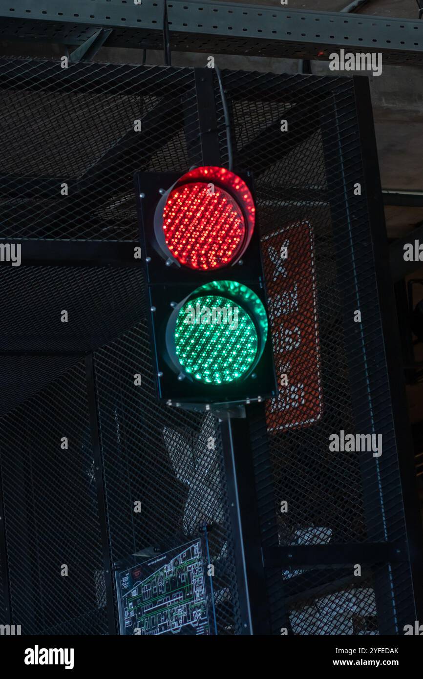 In a dimly lit, dark room, there is a red and green traffic light ...