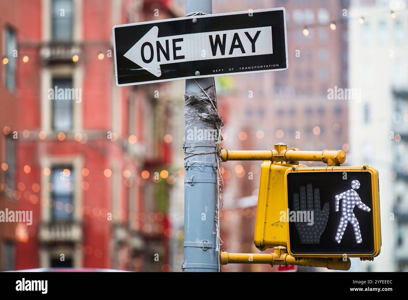 A New York City street sign indicating "One Way" is mounted above a ...