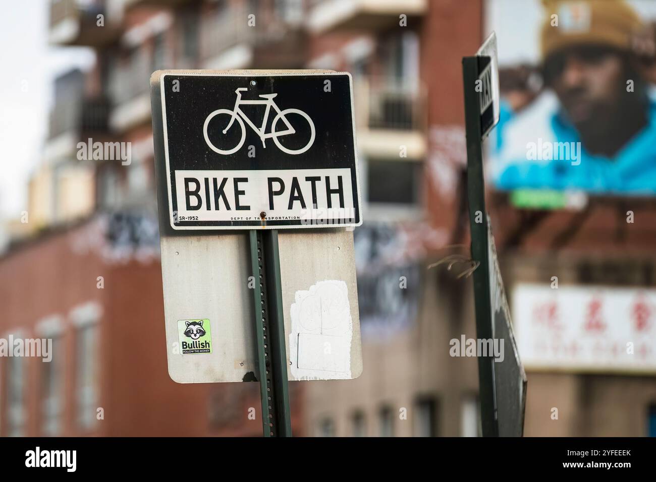 A "Bike Path" sign in New York City is mounted on a pole, with an urban ...
