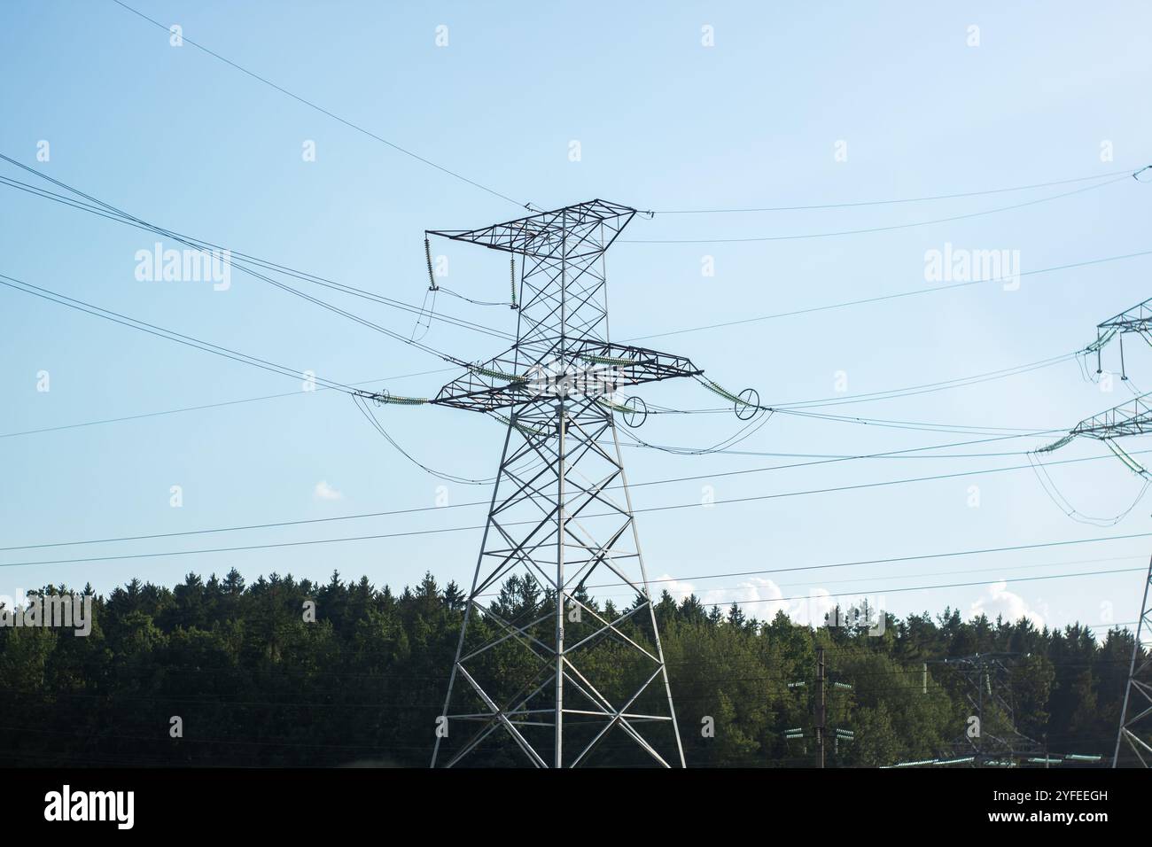 A tall telephone pole stands prominently against a vibrant blue sky ...