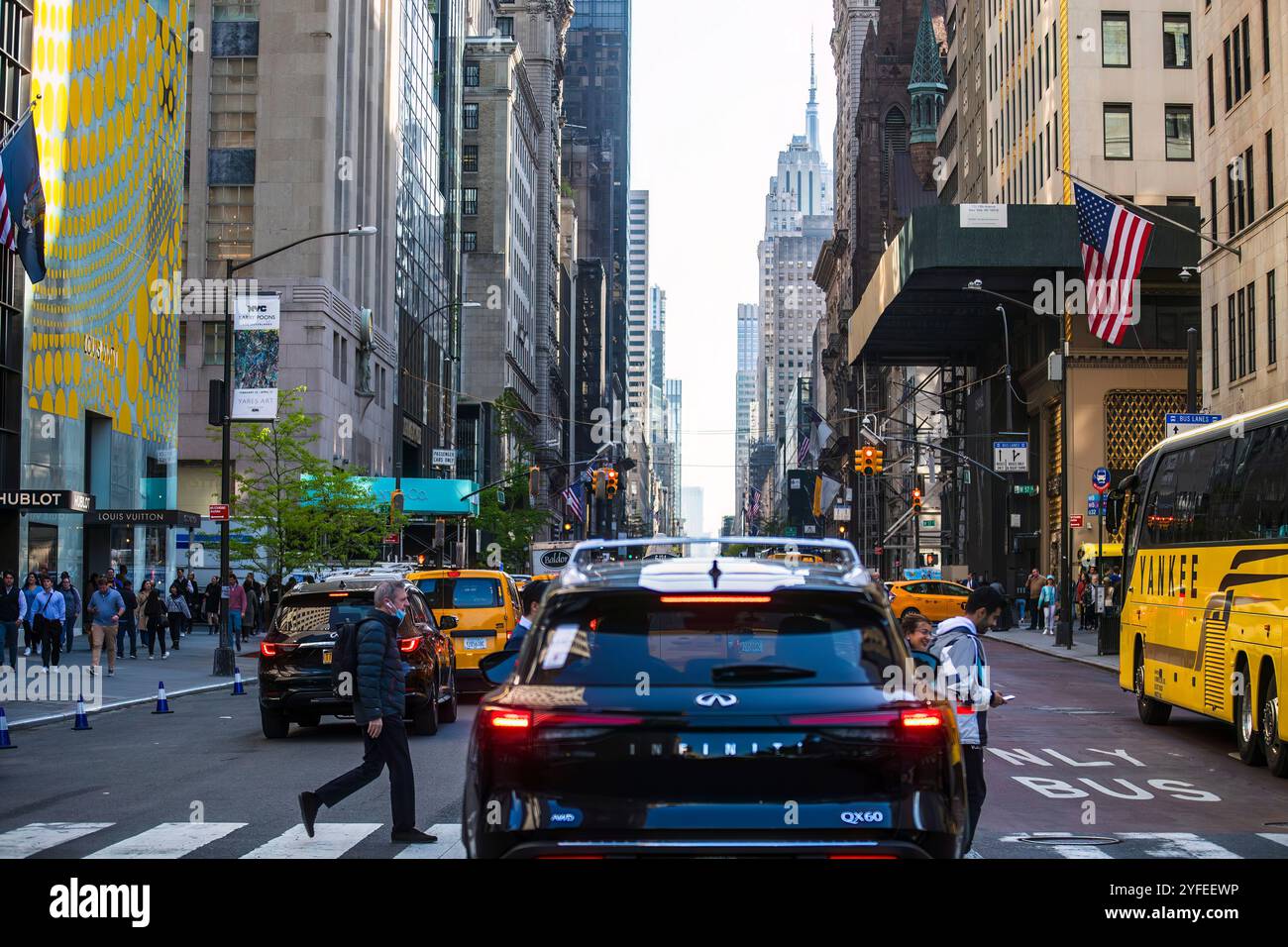 A busy street scene in New York City features pedestrians crossing ...