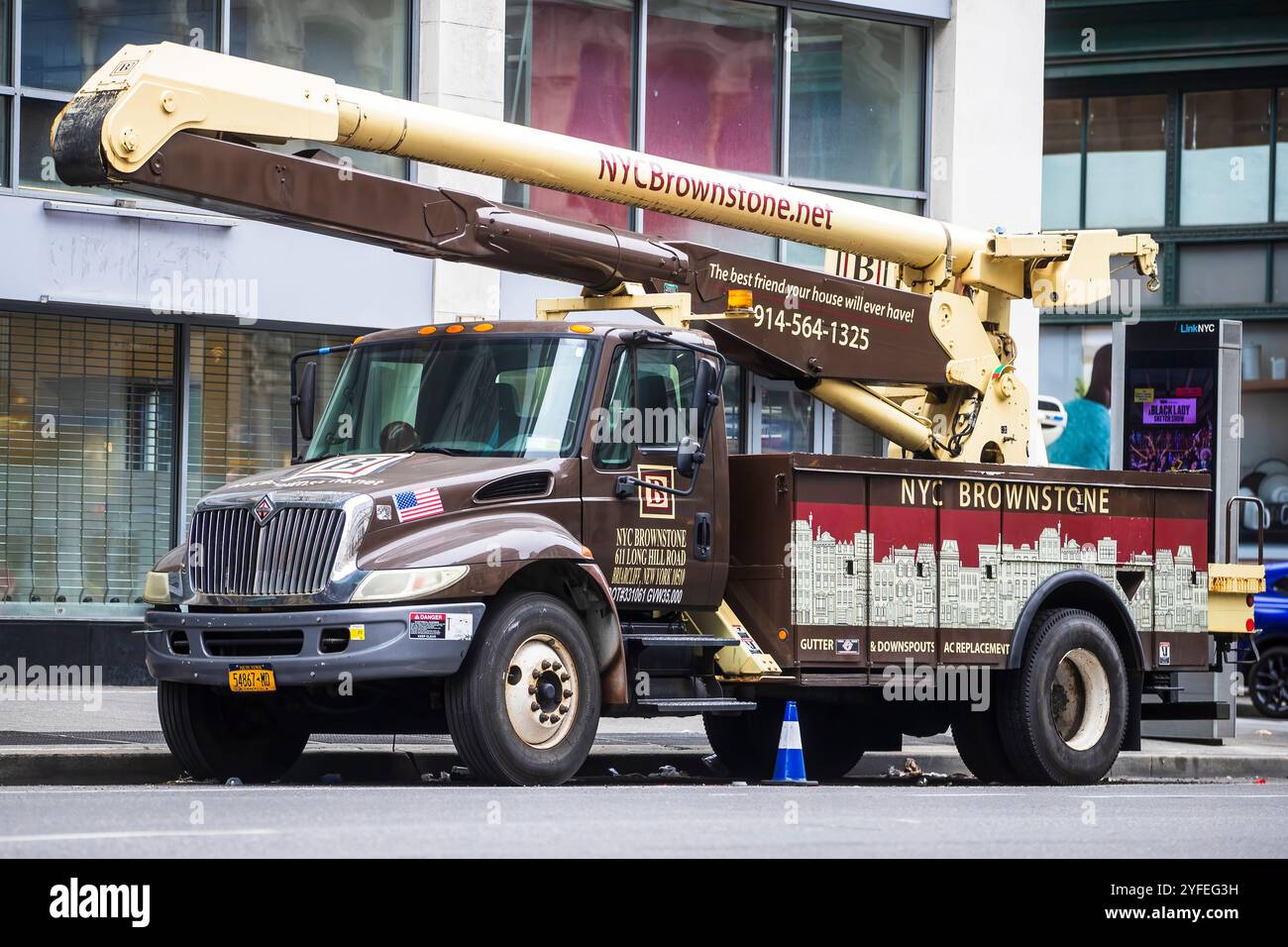 NYC Brownstone construction truck with an extended boom parked on a ...