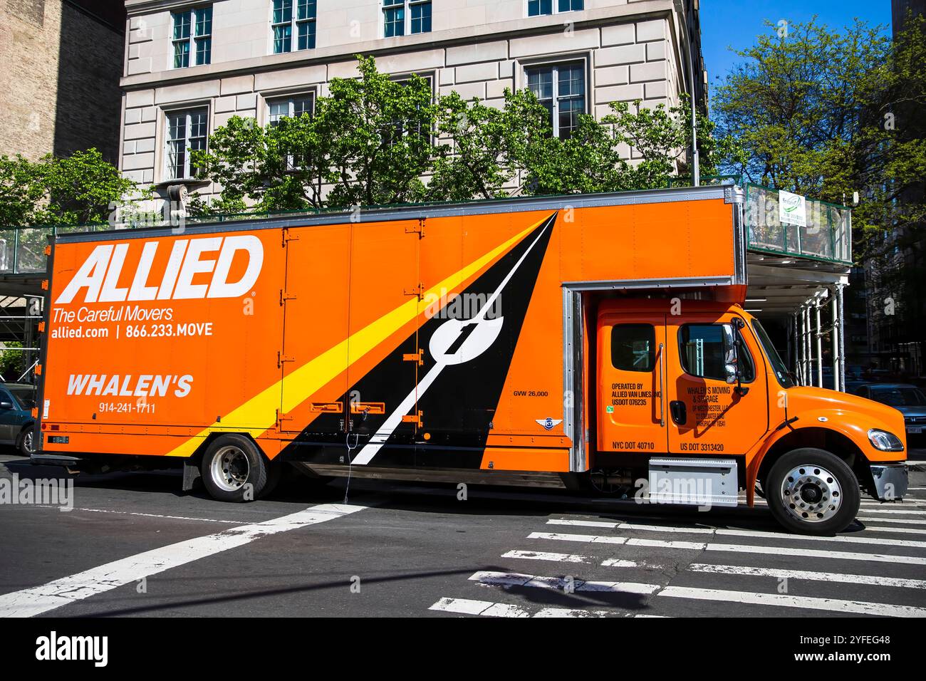 Bright orange Allied moving truck parked at an intersection in New York ...