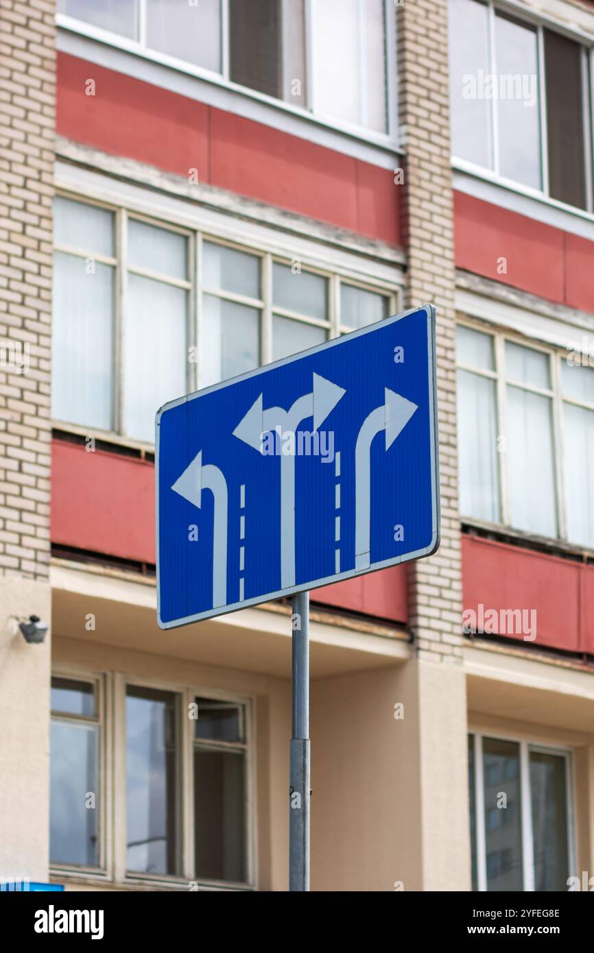 An eyecatching blue street sign features three arrows that are ...