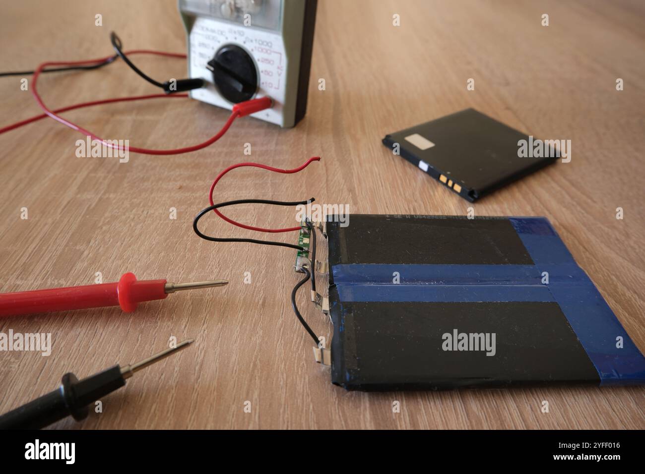Flat cell lithium ion batteries on the table. Testing batteries with ...