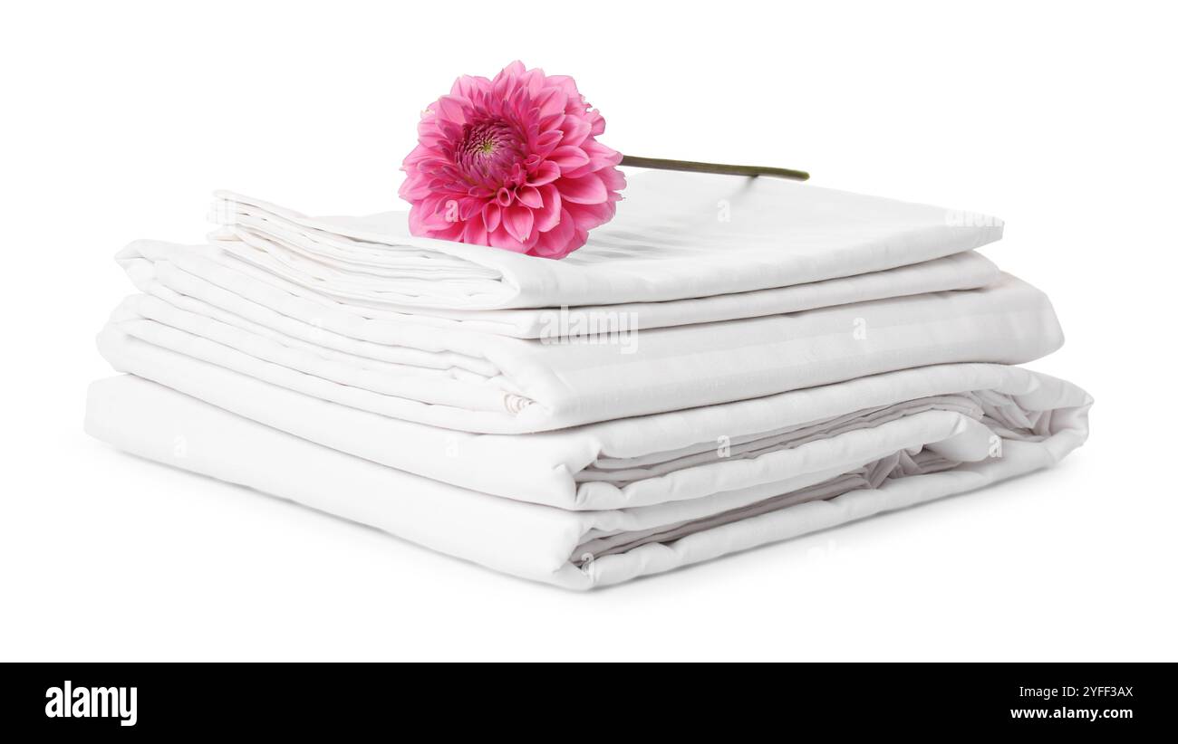Stacked bed linens and pink flower on white background Stock Photo - Alamy