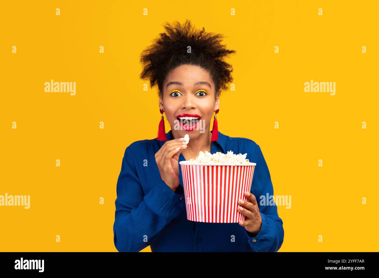 Millennial afro woman with popcorn watching movie Stock Photo - Alamy