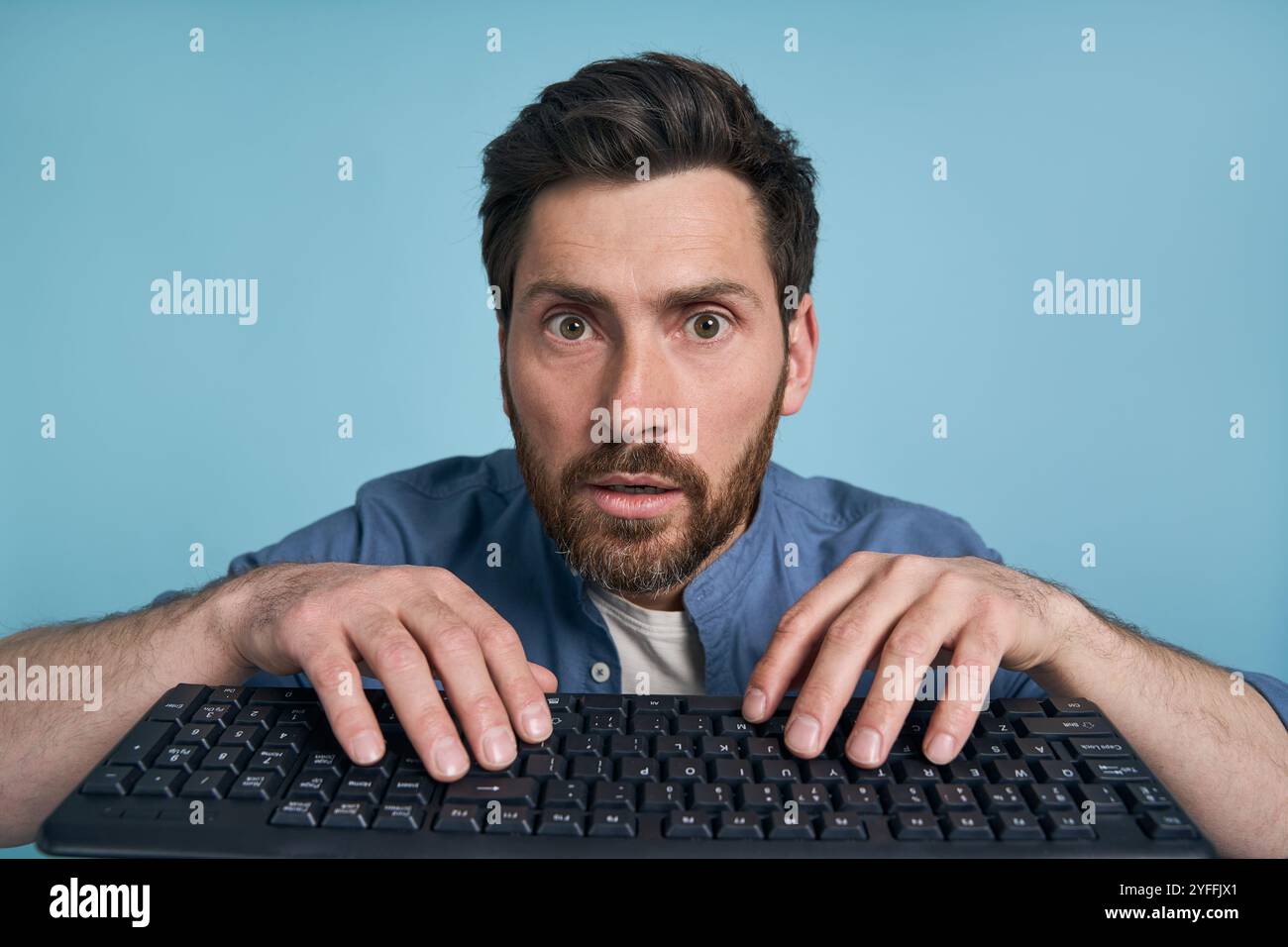 Businessman is anxiously typing on a keyboard with a surprised ...