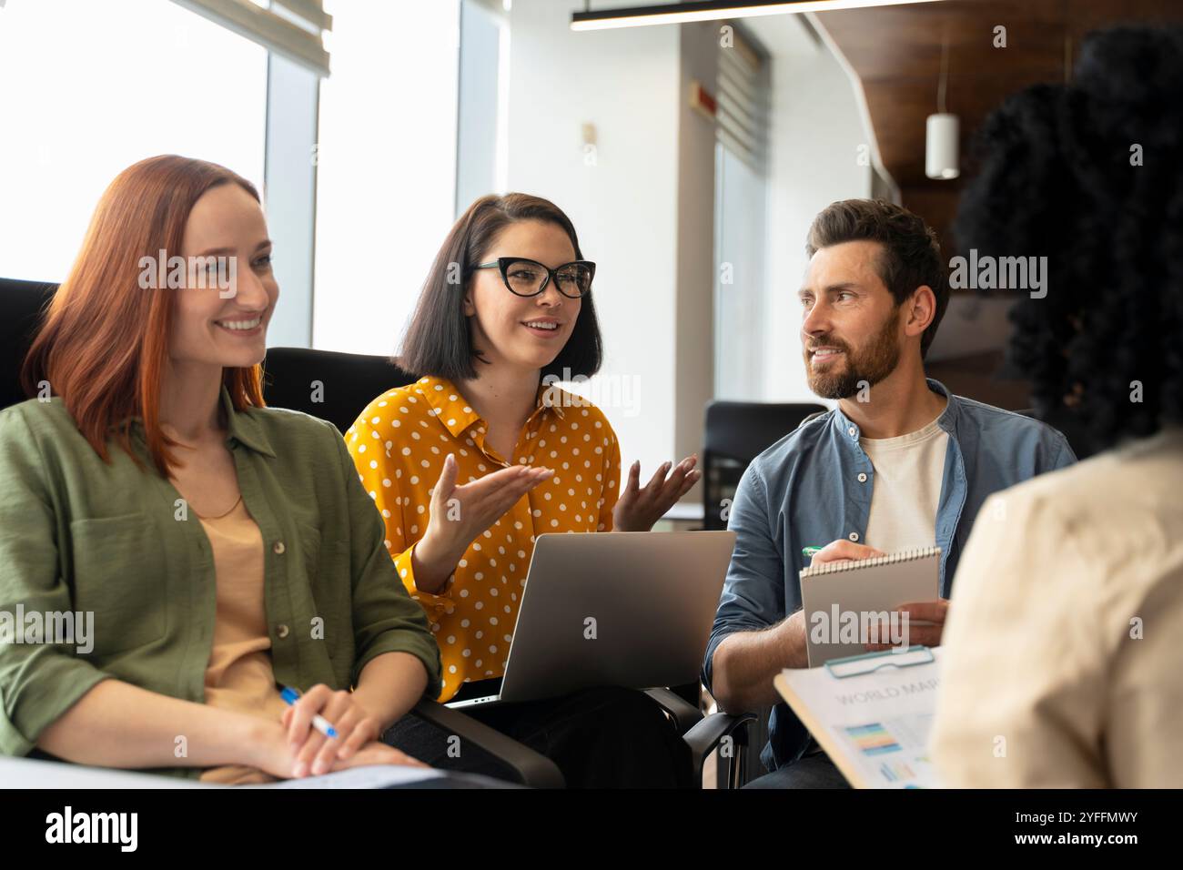 Group of young professionals is having a productive meeting in a modern office, brainstorming ...