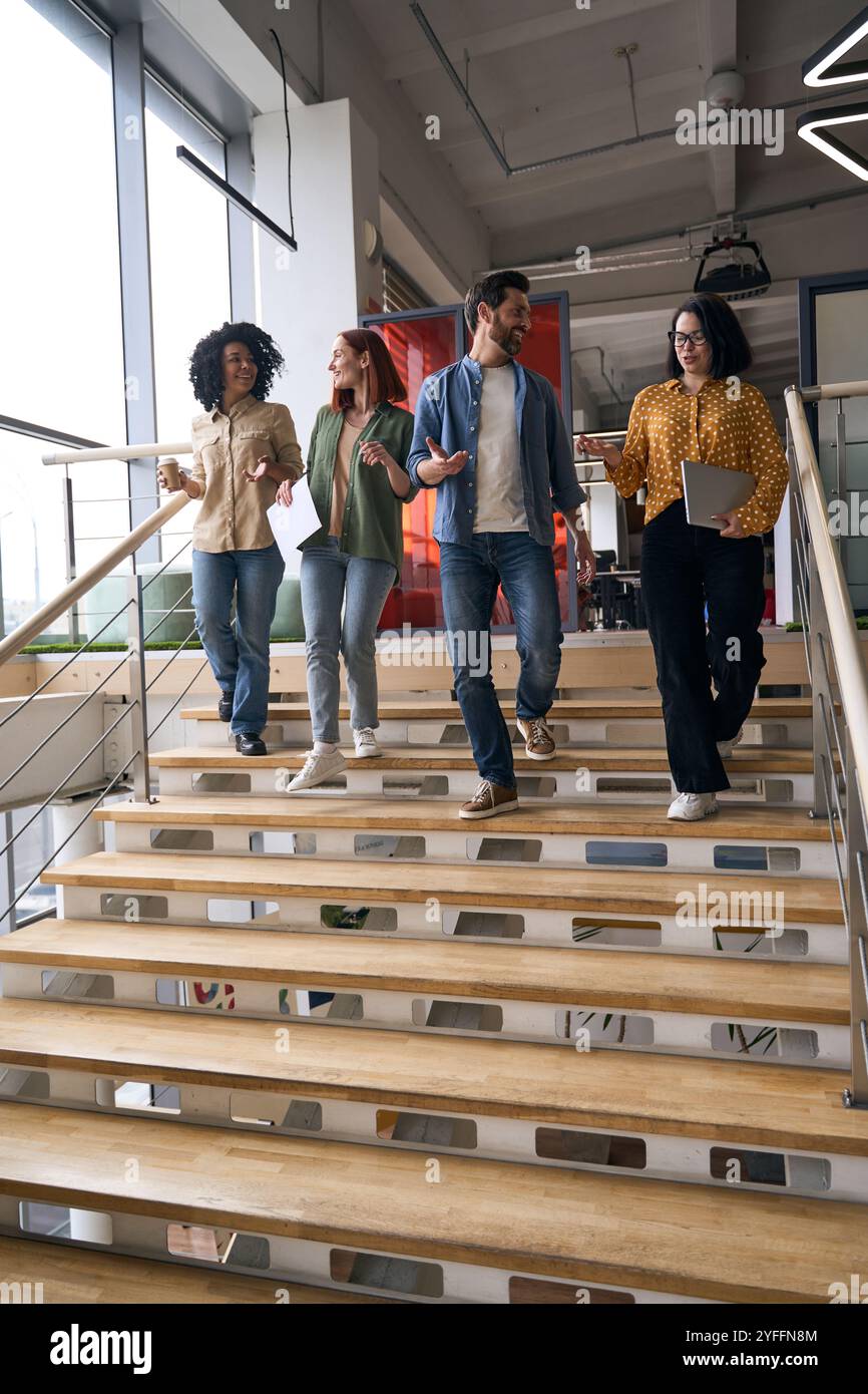 Four business colleagues are having a friendly conversation while ...