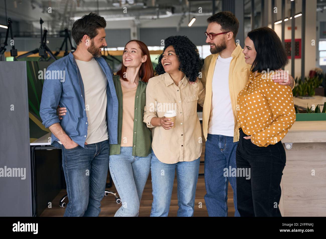 Five colleagues laughing and having fun together during a break in the ...